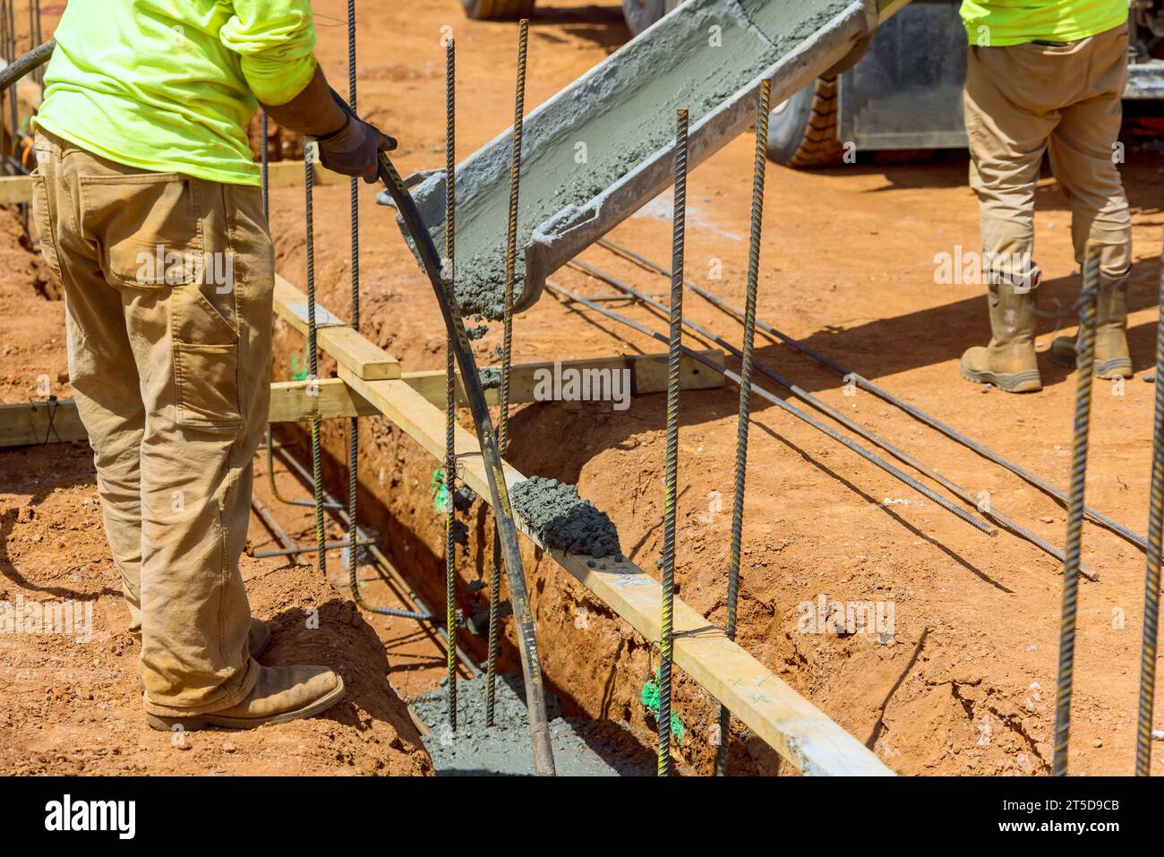 Pouring concrete mix for new house foundation at construction site by ...