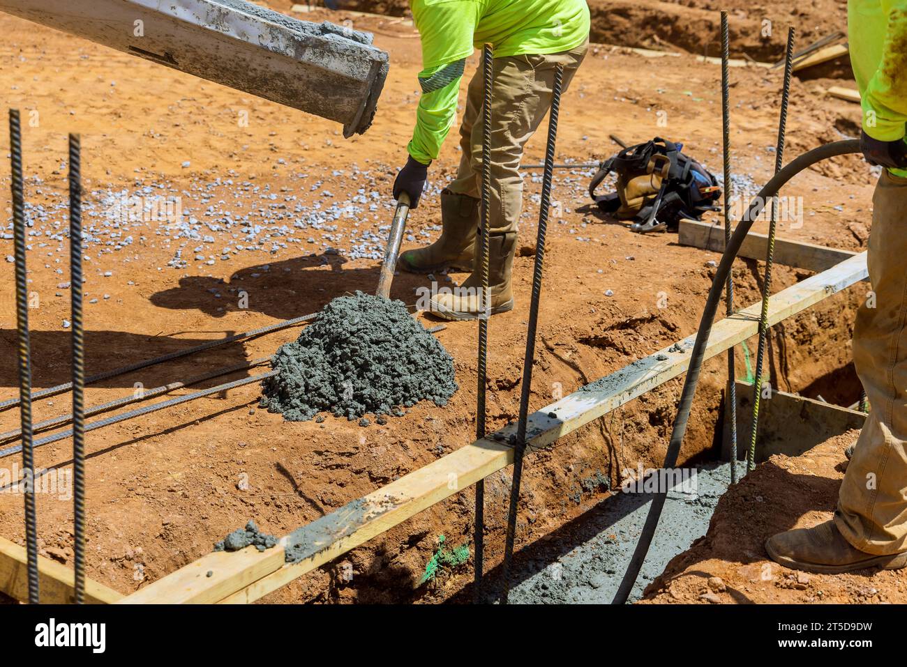 Worker pouring concrete mix foundation for new house on construction ...