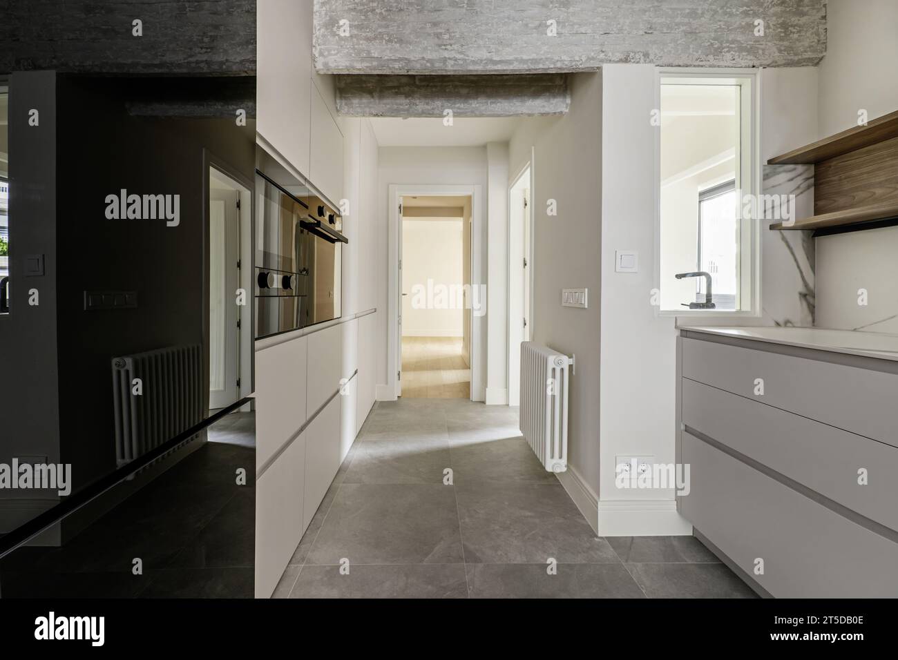 Elongated kitchen with black glass appliances Stock Photo - Alamy