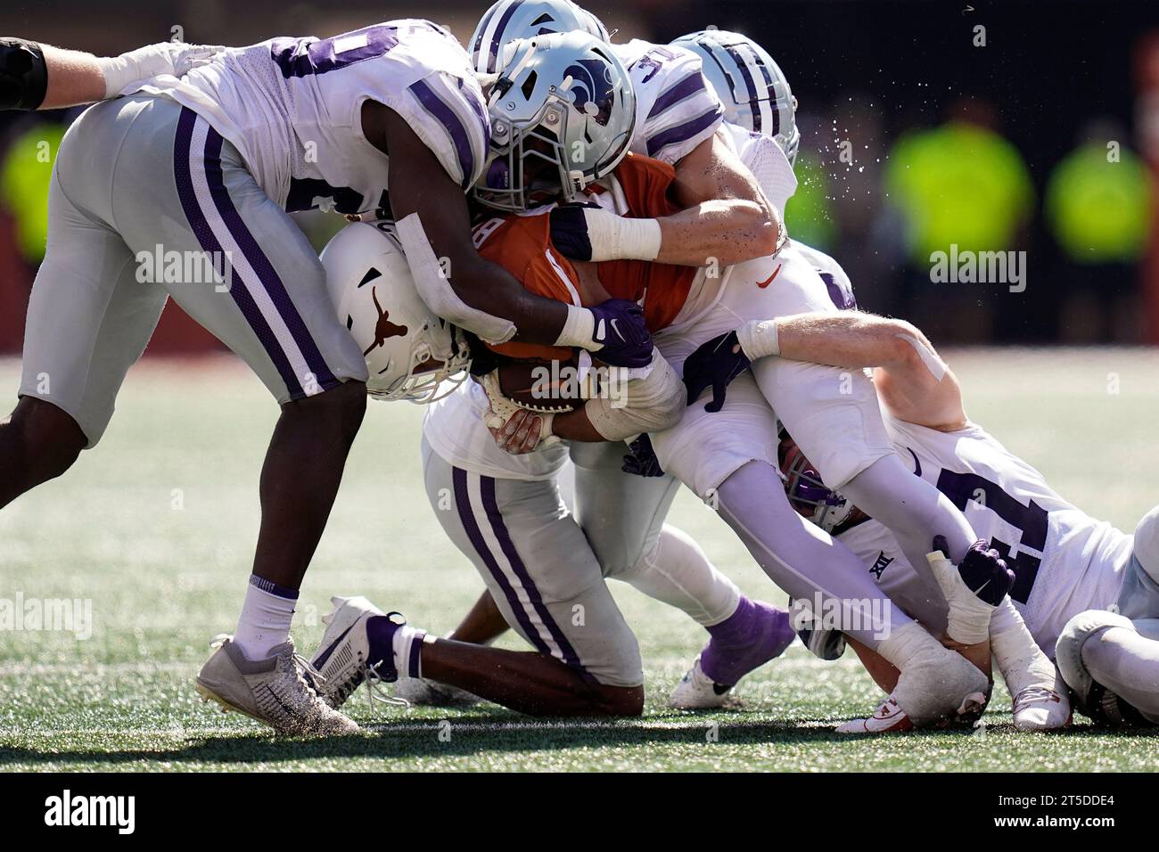 Texas running back Jonathon Brooks, center, is stopped by Kansas State ...