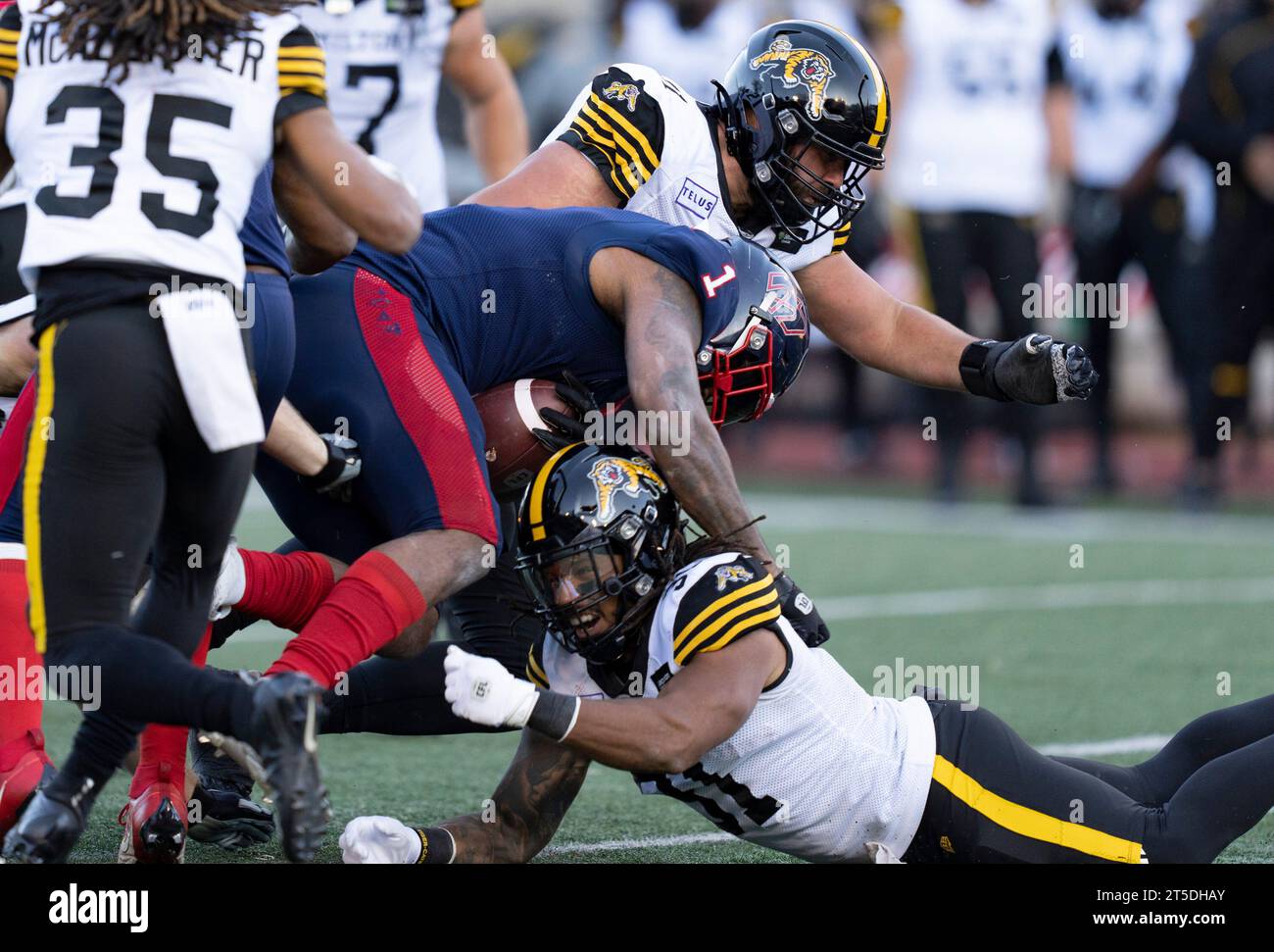 Hamilton Tiger-Cats running back Sean Thomas Erlington, bottom, tackles ...