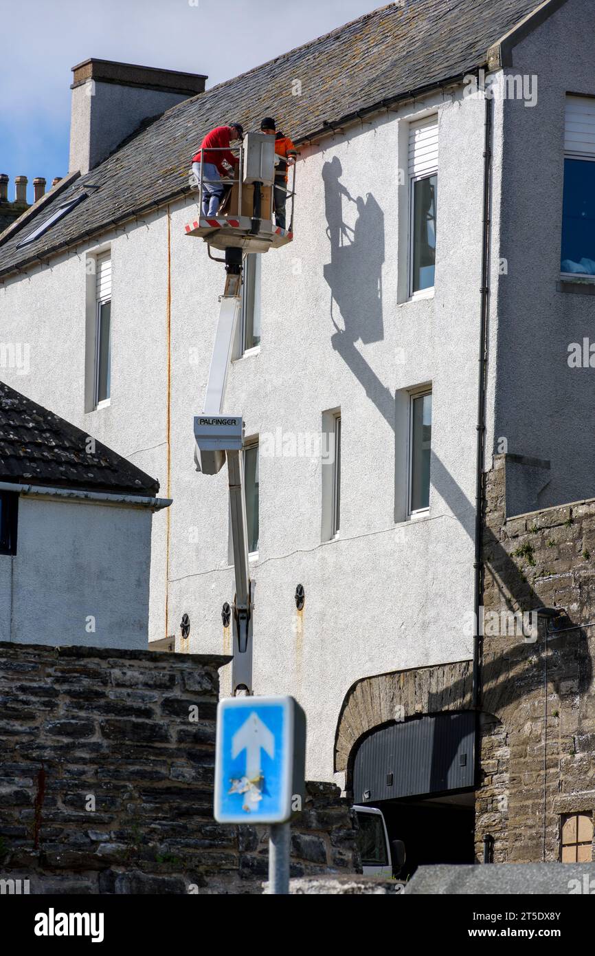 Two workmen on an access platform working on a building above the Black ...
