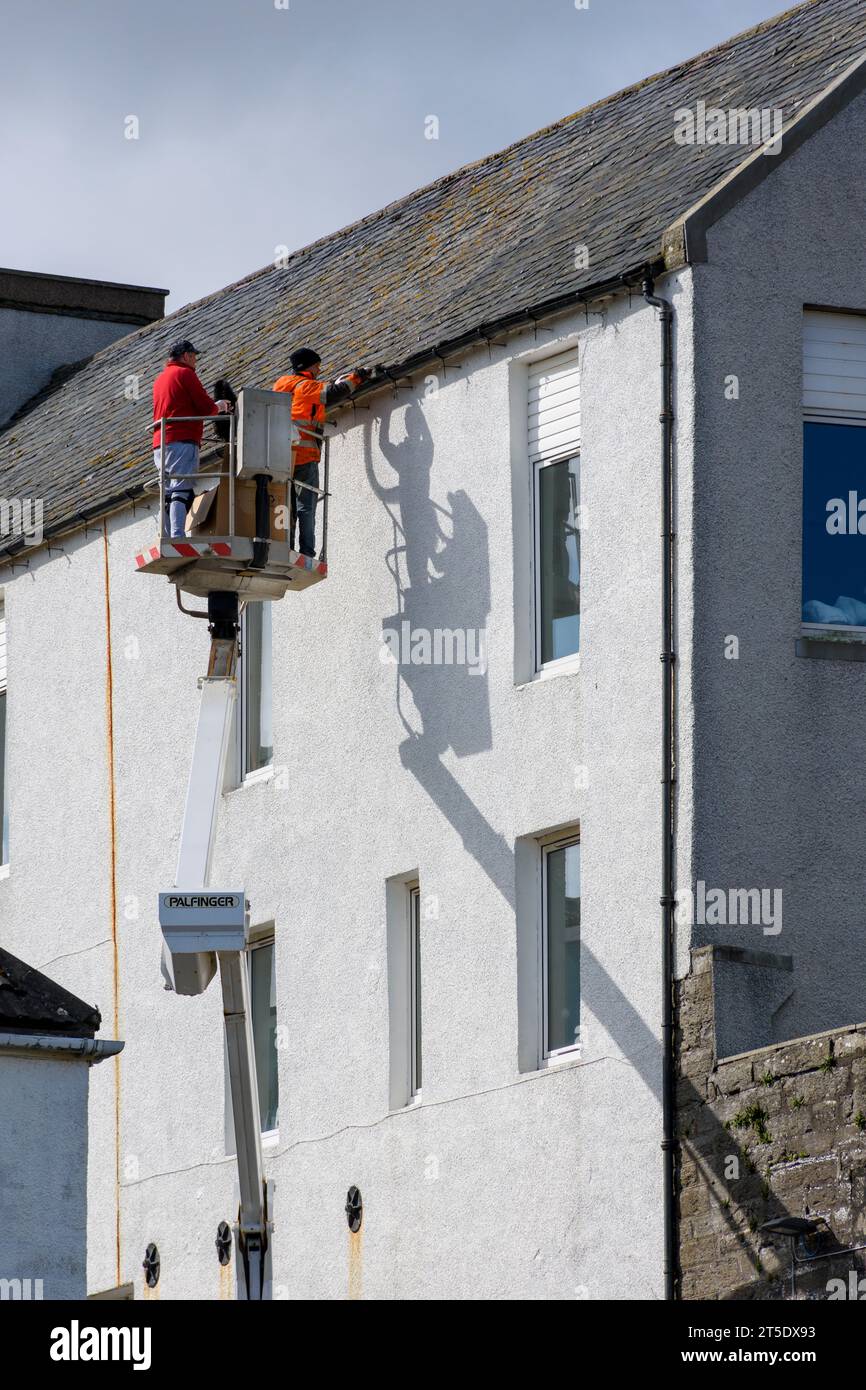 Two workmen on an access platform working on a building above the Black ...