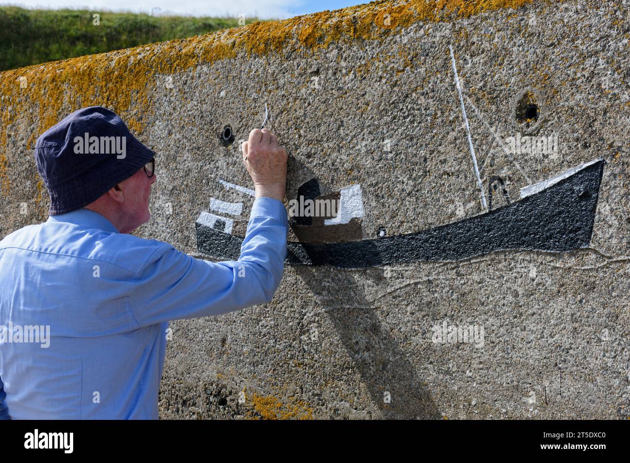 Derry Ross repainting one of his original paintings of a boat, on the ...