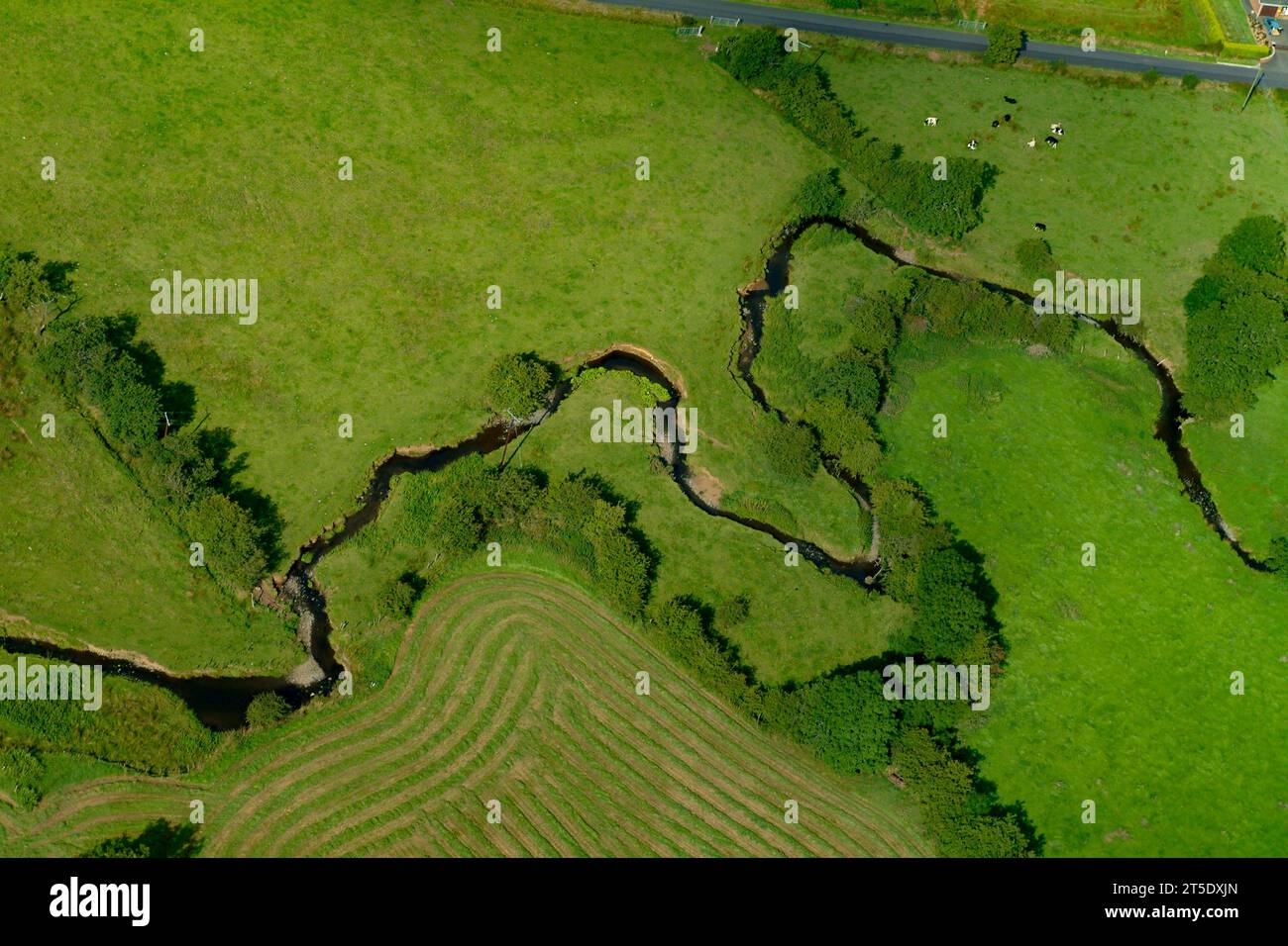A small stream runs through fields in the Irish Countryside, County ...