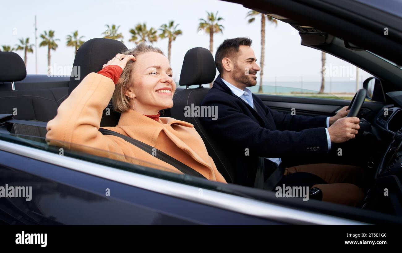 Happy mature couple having fun driving on convertible car. People ...