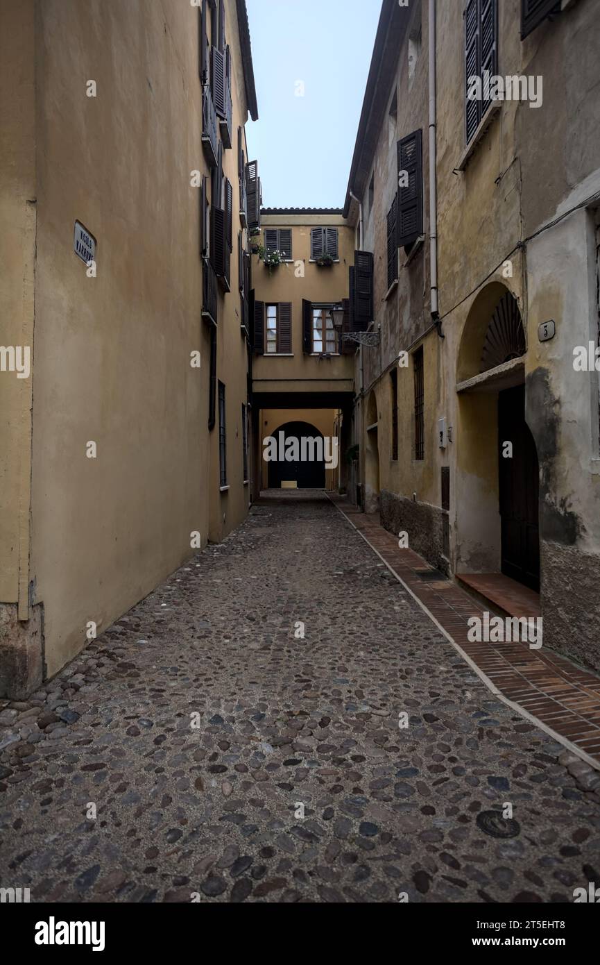 Cobbled and narrow alley between buildings on a cloudy day in an ...
