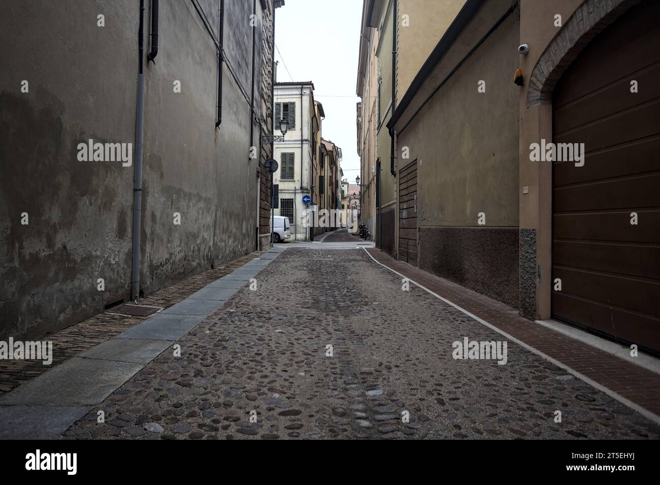 Cobbled and narrow alley between buildings on a cloudy day in an ...