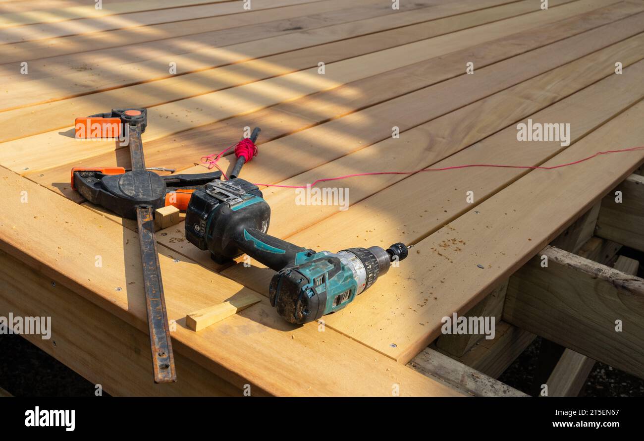 Old builders tools and red string on new wooden decking under ...