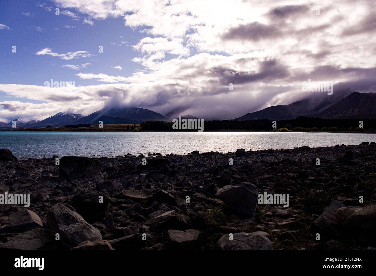 Dramatic view of Lake Tekapo with the clouds rolling in and changing ...