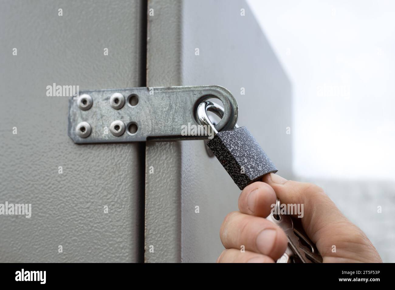 an iron lock on the lid of the electrical panel, which is closed by a ...