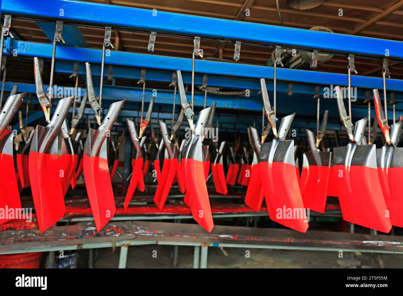 Steel spade spray paint production line Stock Photo - Alamy