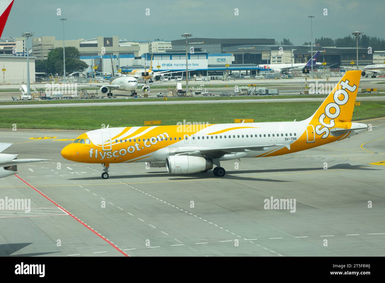 Side view of Airbus A320-232 on the busy ground at Singapore Changi ...