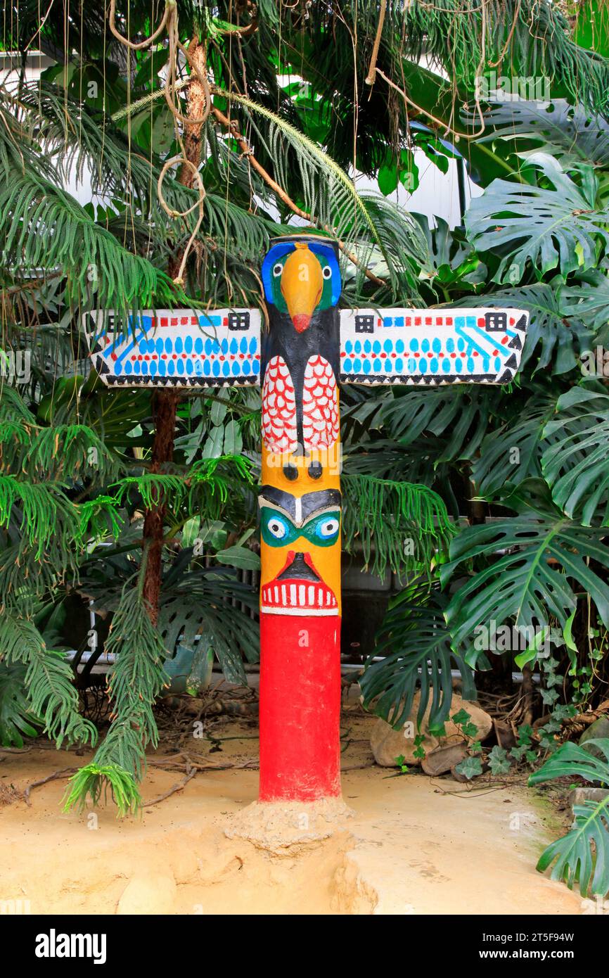 Totem poles and tropical plants in a garden Stock Photo - Alamy