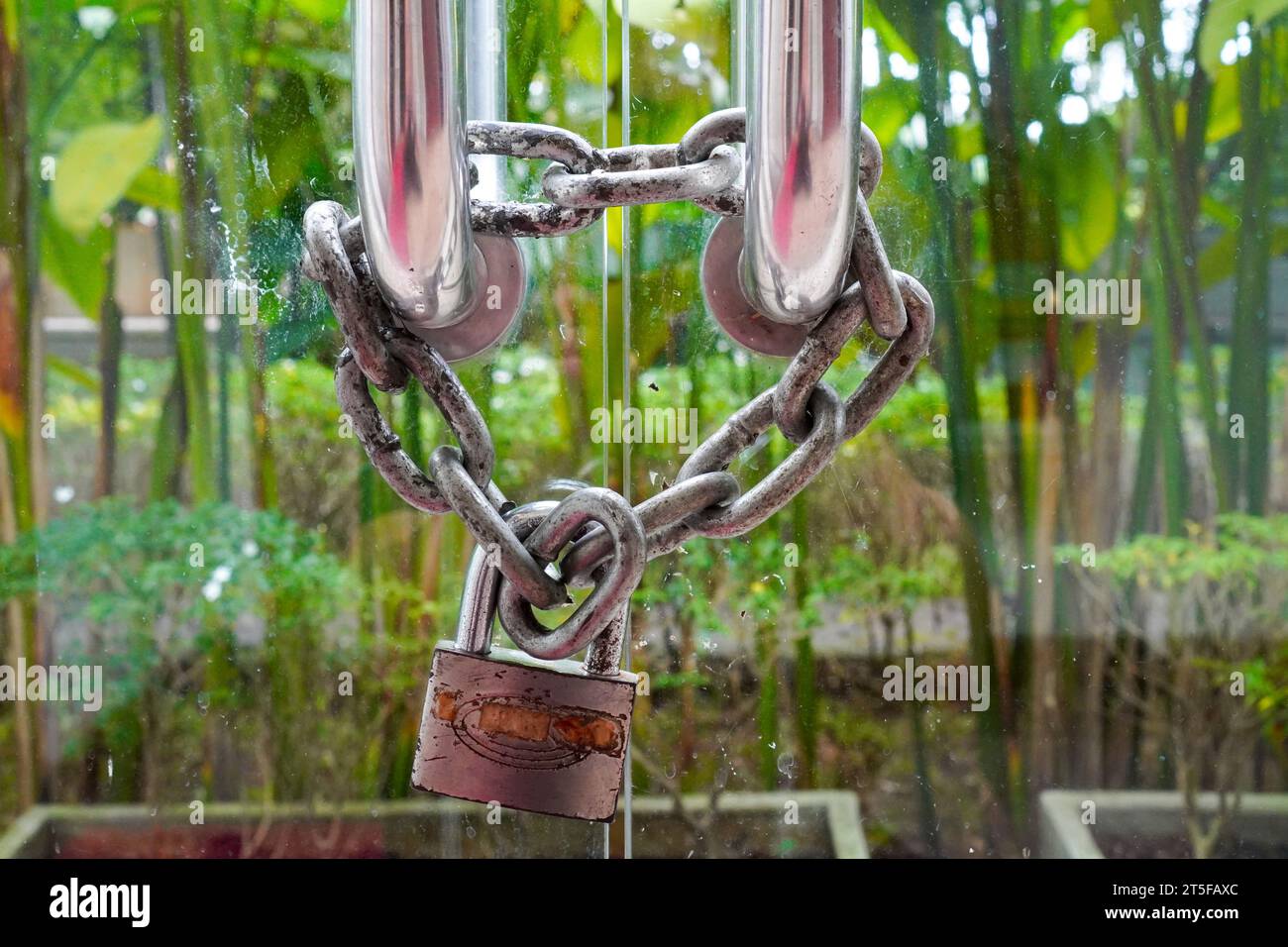 Close-up photo of iron chain and iron padlock on glass door Stock Photo ...