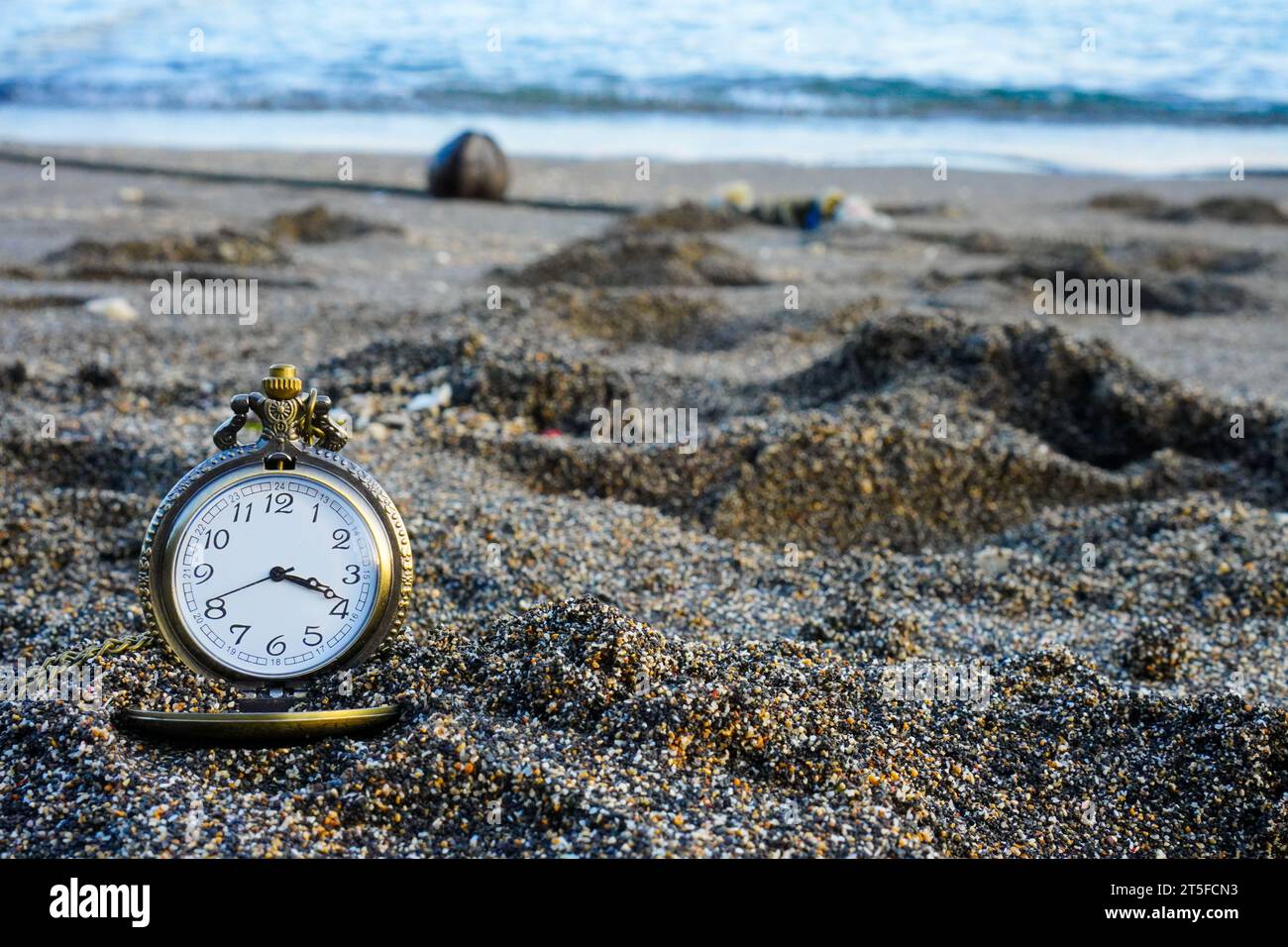 Gold pocket watch on beach sand with beach waves background Stock Photo ...