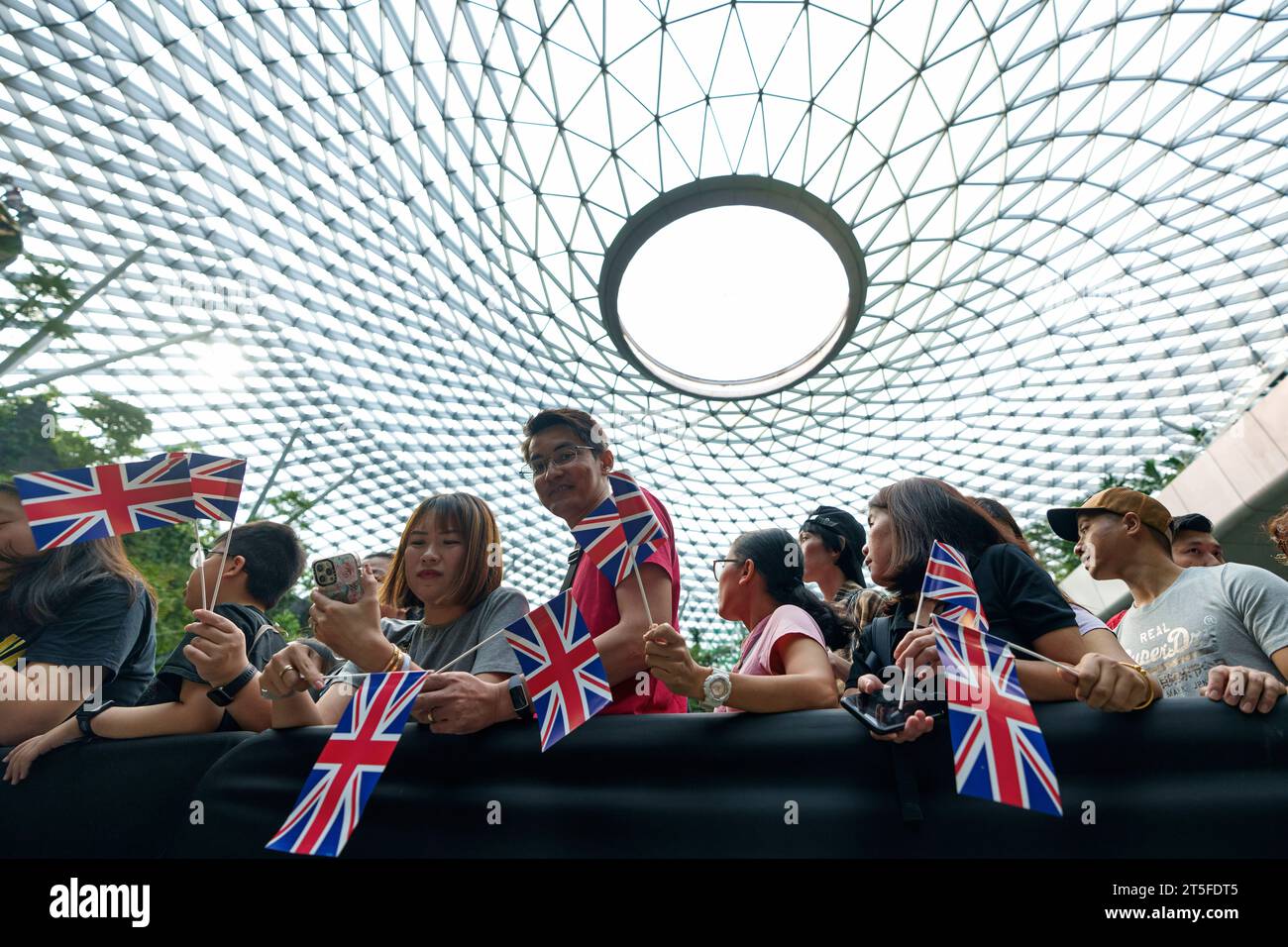 Singaporean hold British flags as they wait for the arrival of Britain ...