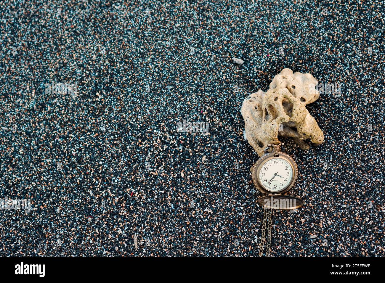 Gold color pocket watch lying on the sand. With copy space for text ...