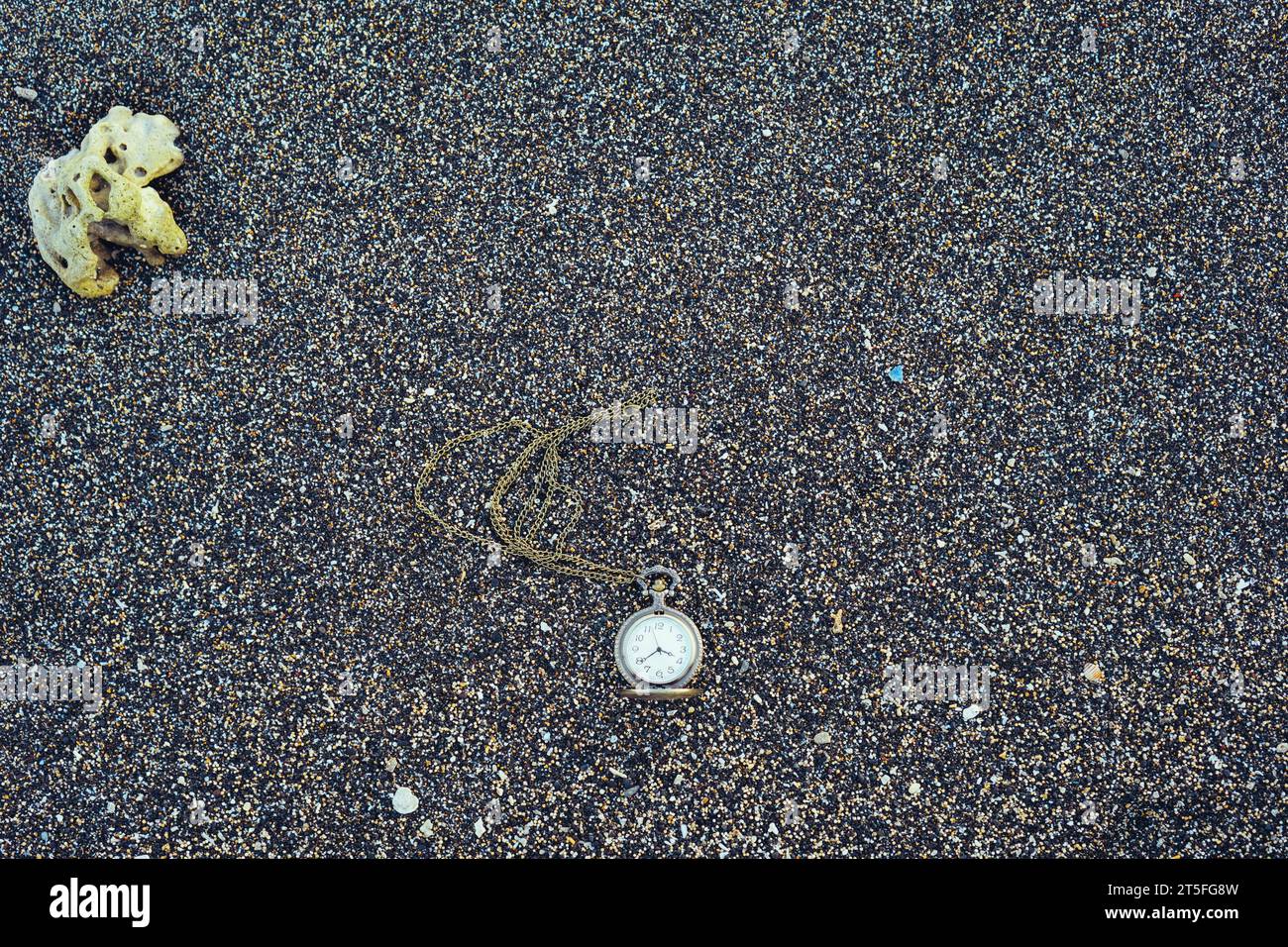 Gold color pocket watch lying on the sand. With copy space for text ...