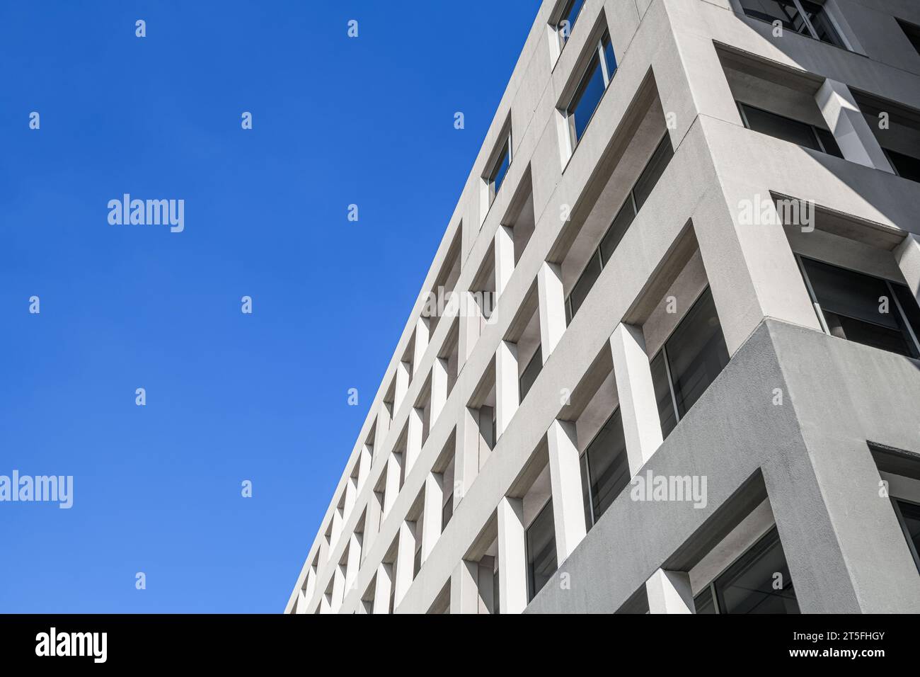 Facade of a concrete office building with glass windows. Wide low angle ...