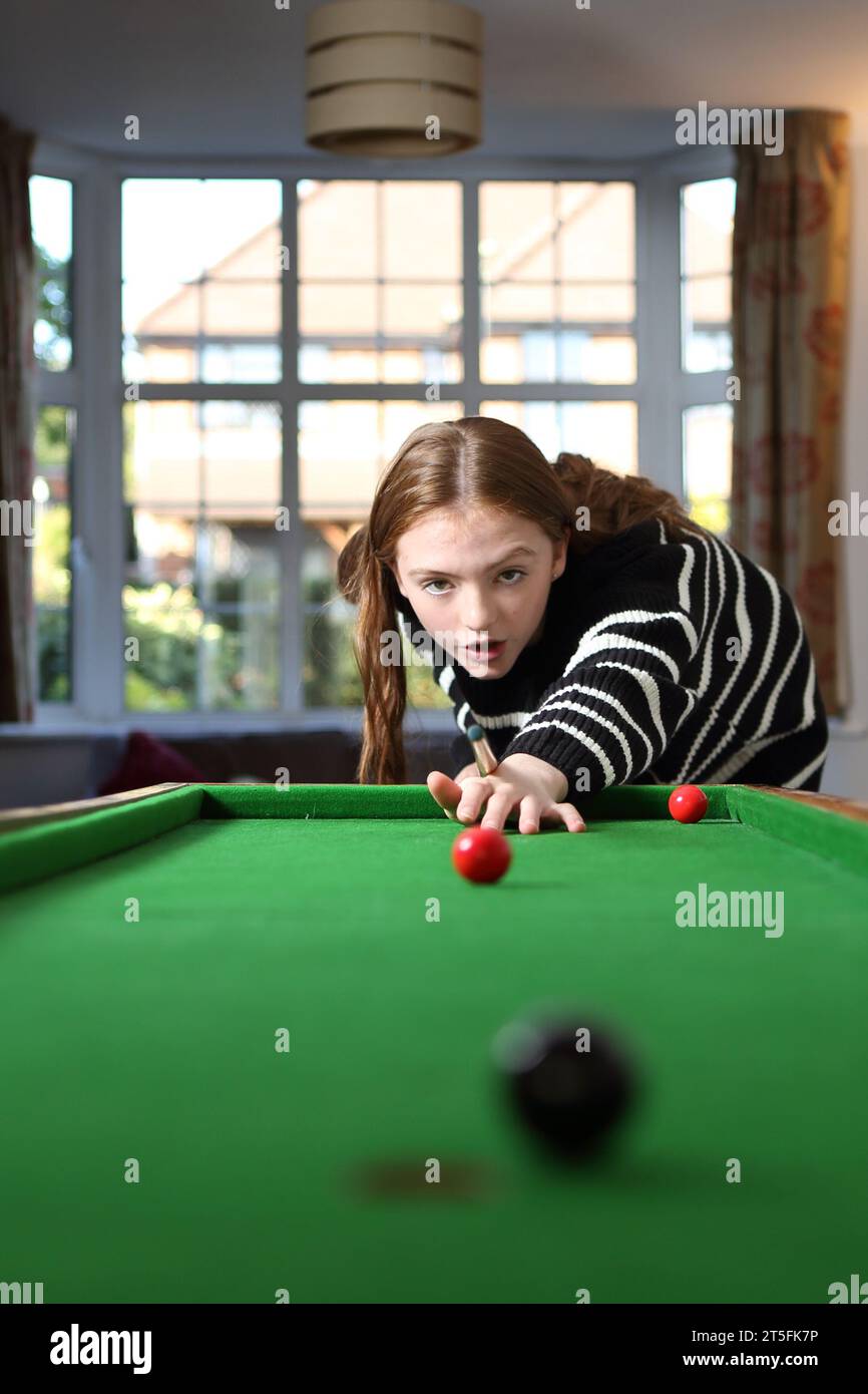 Girl playing bagatelle in lounge at home Stock Photo - Alamy