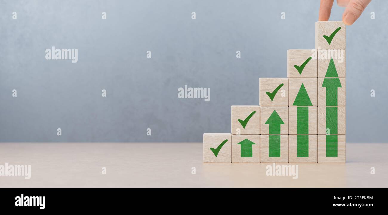 Wooden blocks checklist and green check mark icons with hand on table ...