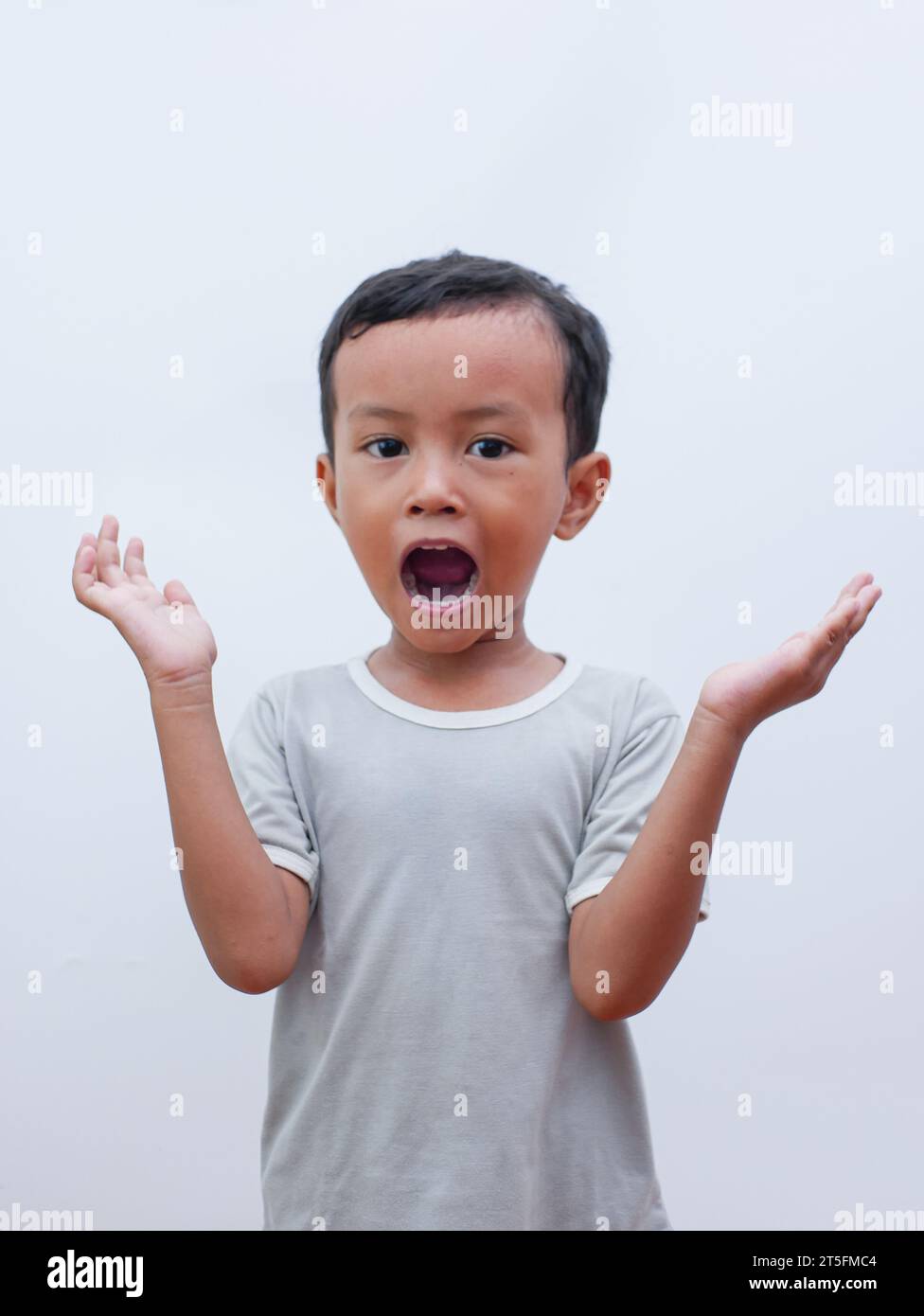 Portrait of a little asian boy looking surprised with his mouth open ...