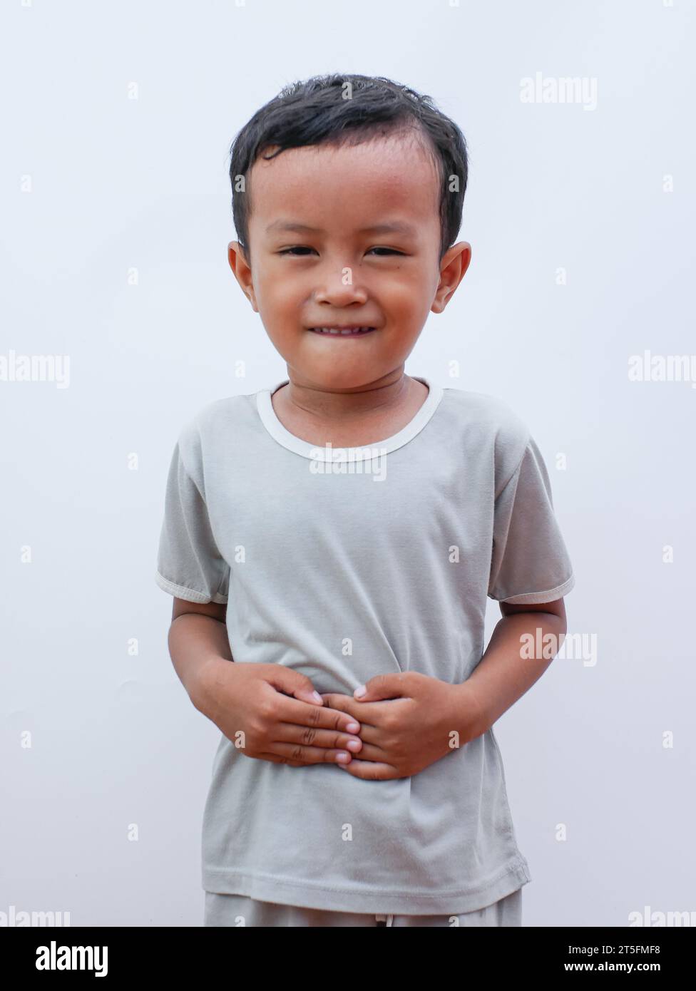 Portrait of a little asian boy suffering from stomach ache isolated on ...