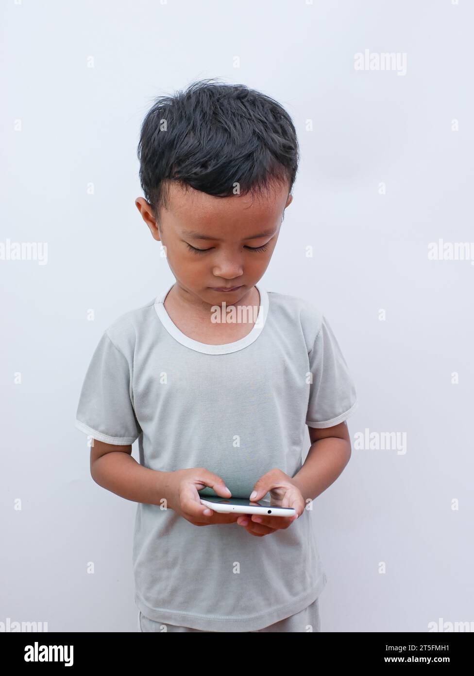 Smiling indonesian boy mobile phone hi-res stock photography and images ...