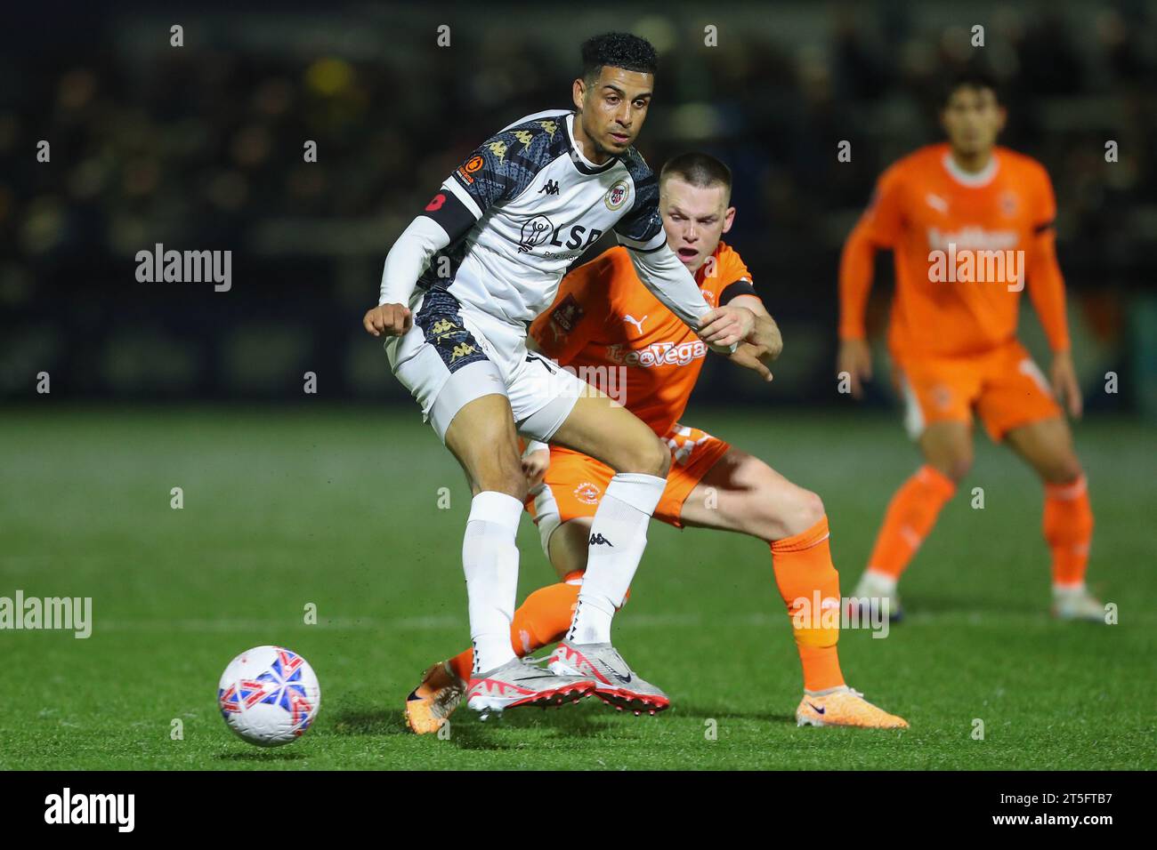 Louis Dennis #11 of Bromley holds off Andy Lyons #24 of Blackpool ...