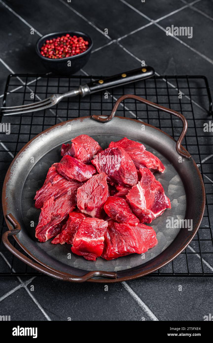 Pieces of raw diced beef fillet meat. Black background. Top view Stock ...