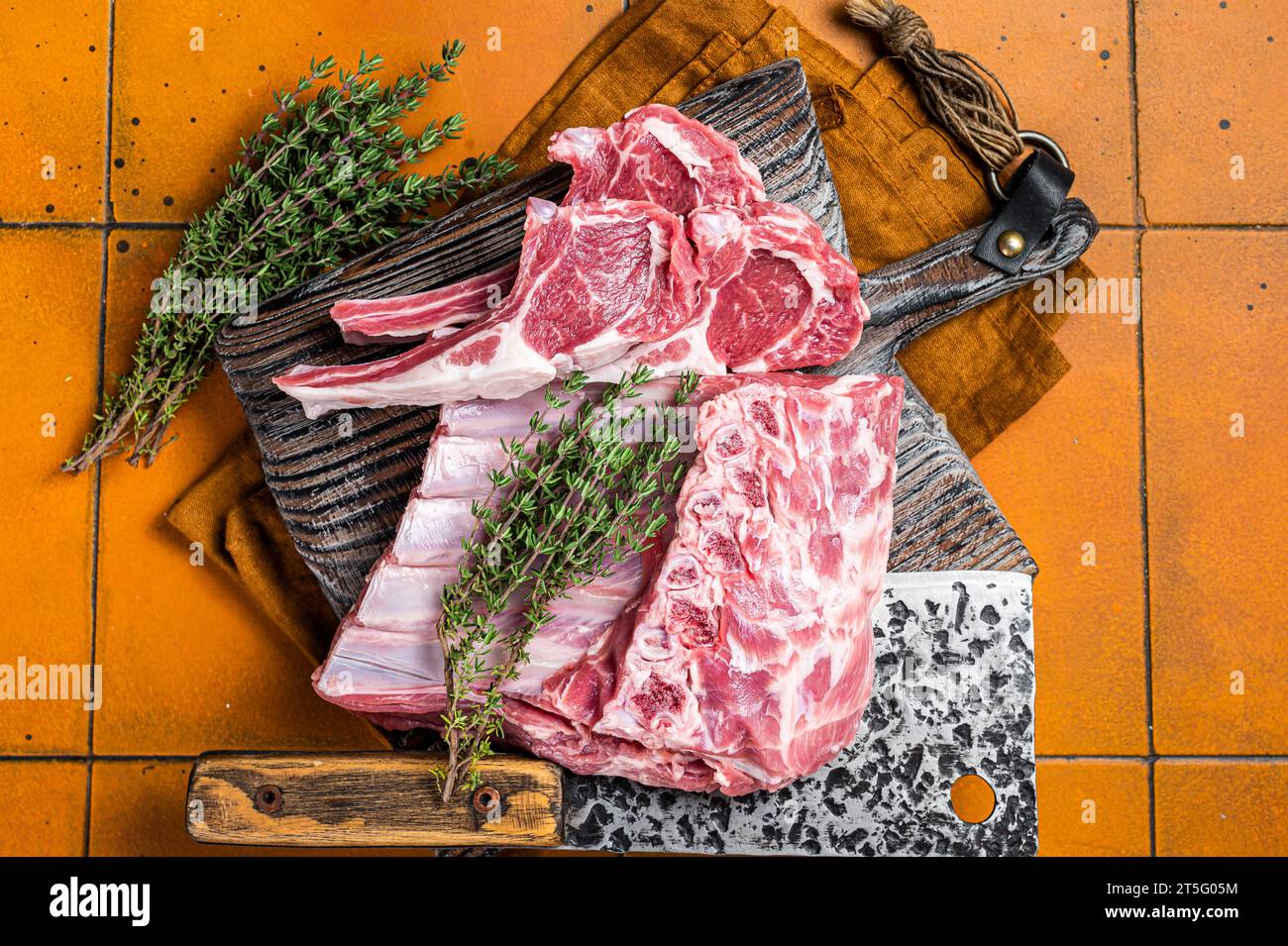 Raw lamb meat chops cutlets on butcher cutting board. Orange background ...