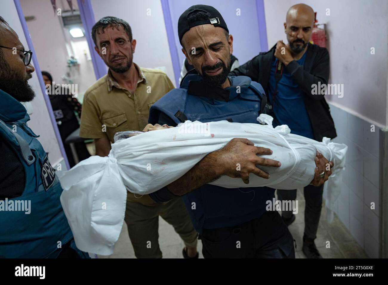 Palestinian journalist Mohammed al-Aloul carries the body of his child ...