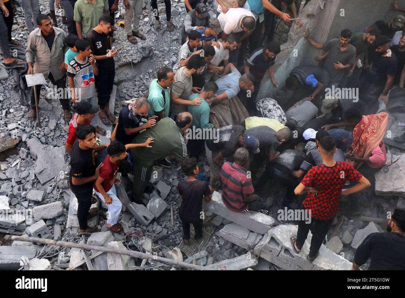Locals conduct a search and rescue operation after Israeli attacks ...