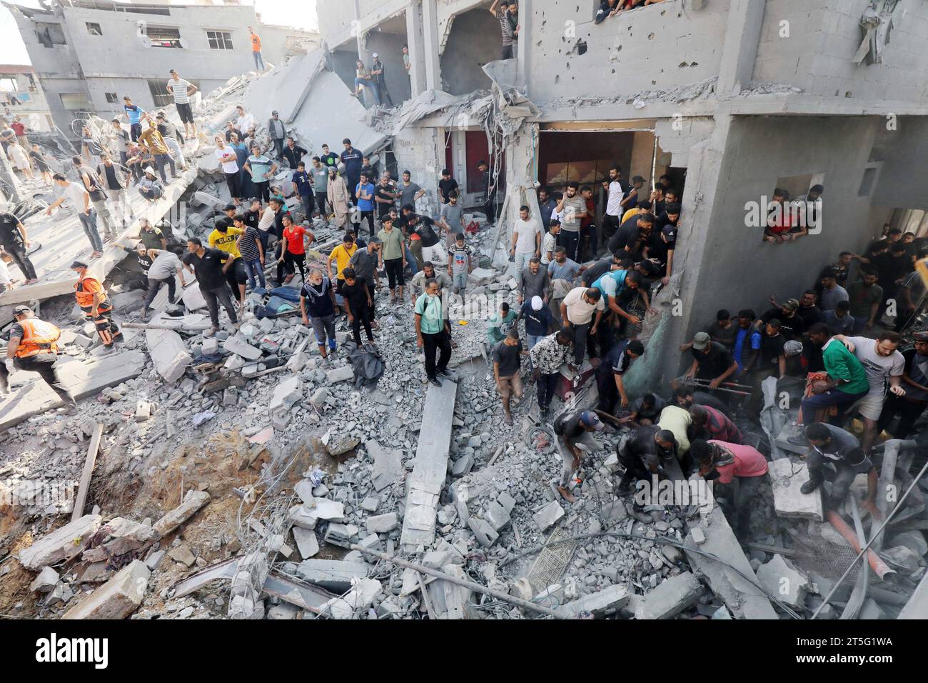 Locals conduct a search and rescue operation after Israeli attacks ...