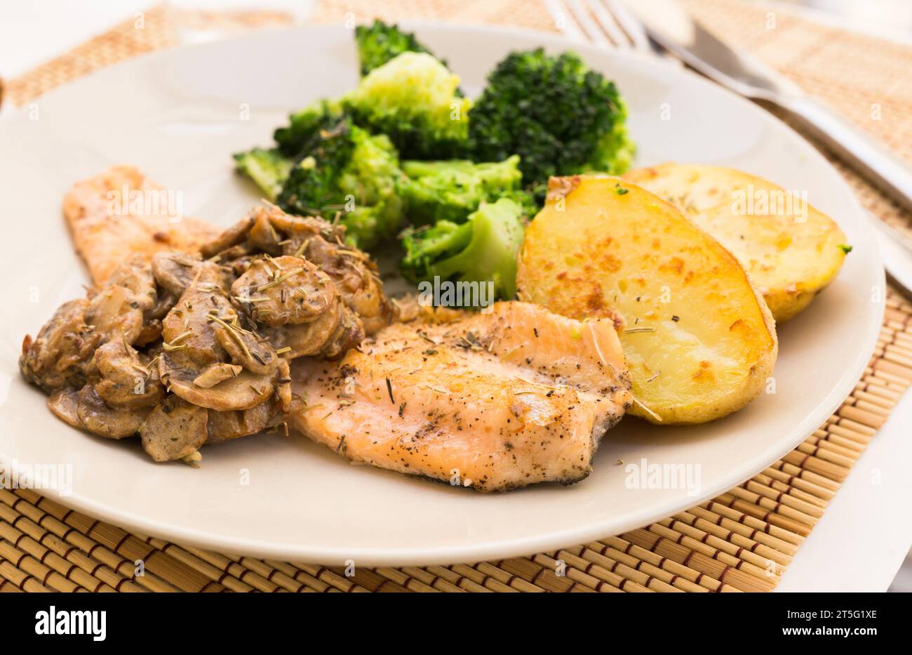 Fried river trout fillet with a complex side dish of broccoli, baked ...