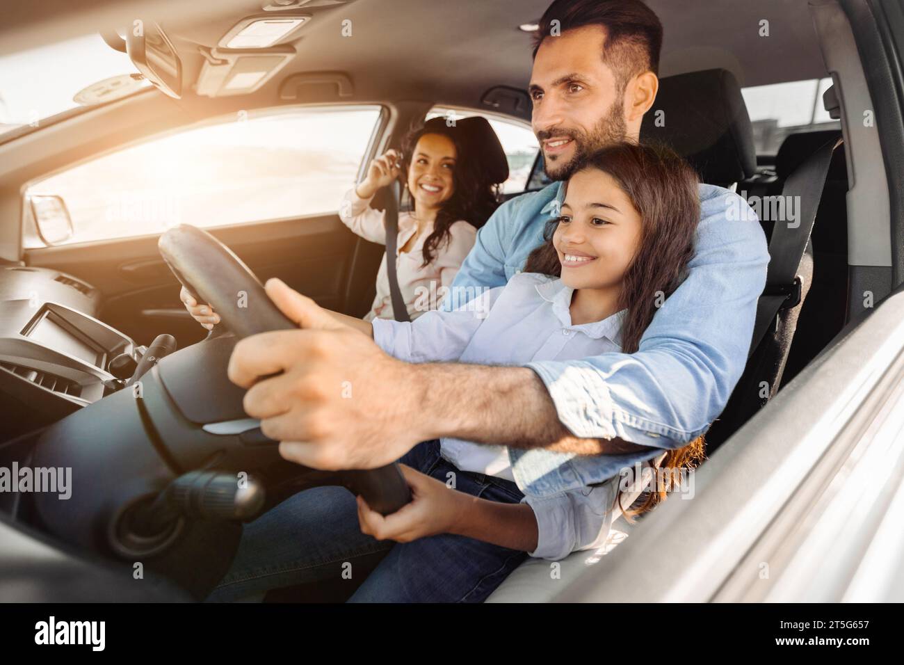 Happy family on a drive, dad at the wheel, daughter co-pilot Stock ...