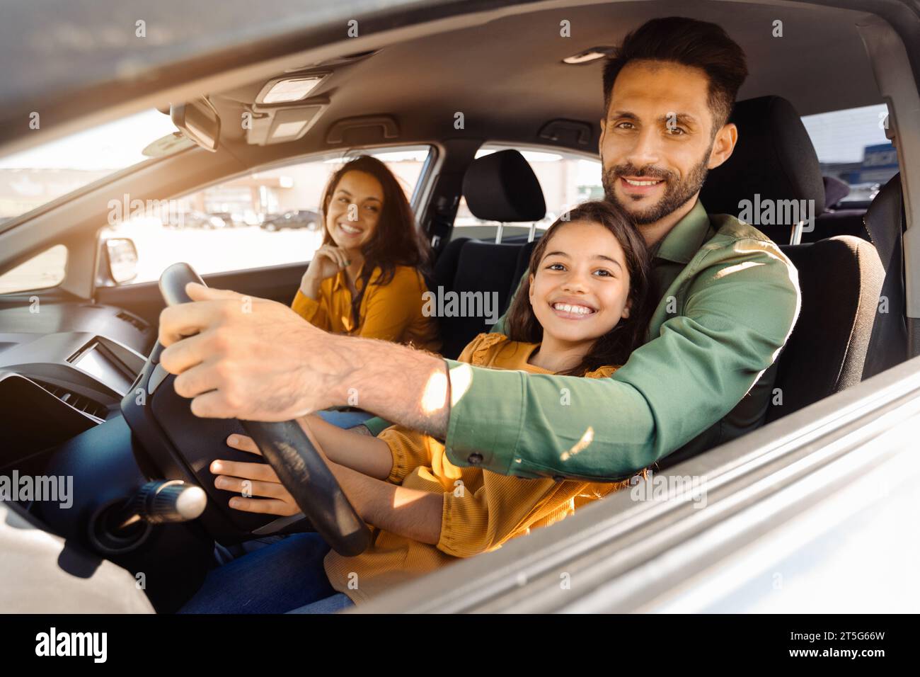 Loving family in car, dad drives with daughter while mom smiles Stock Photo - Alamy