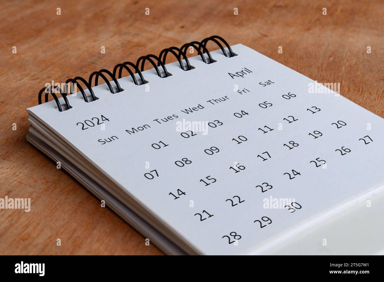 April 2024 white table calendar on wooden background. Calendar concept ...