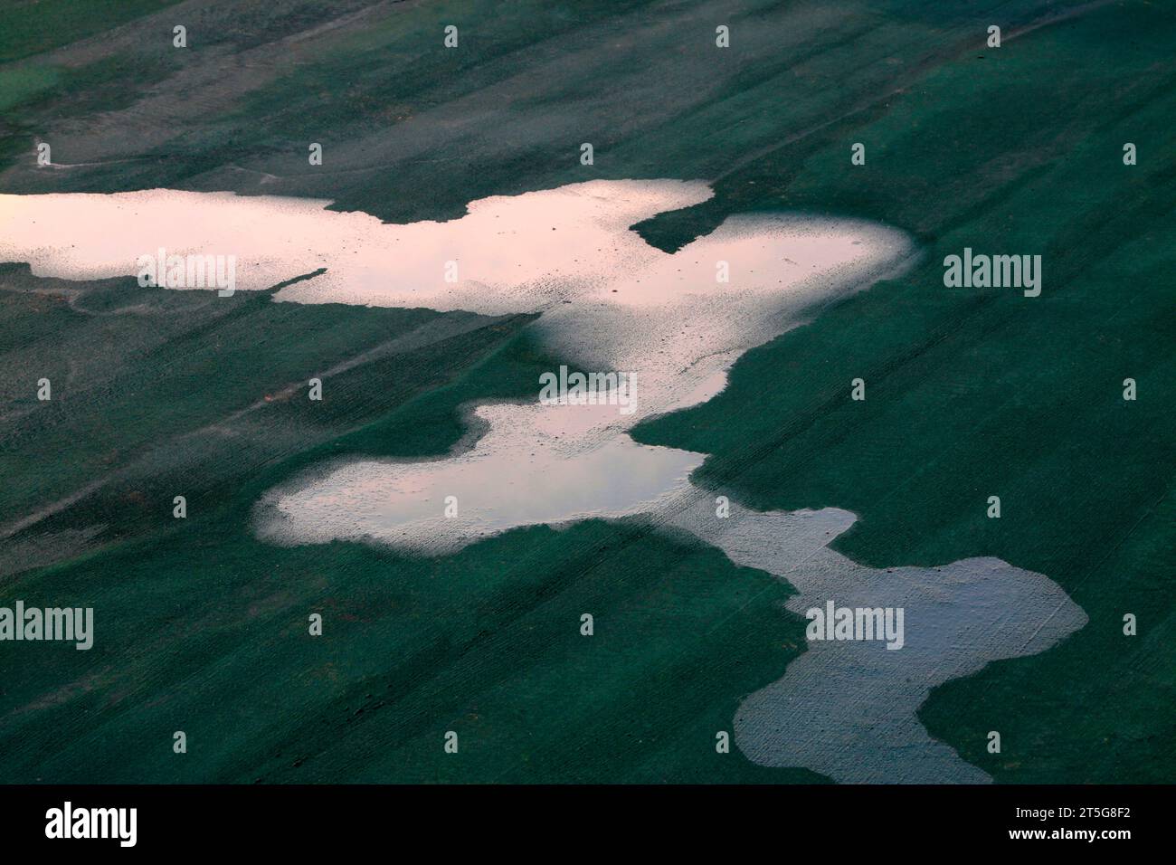 Unfinished green plastic ground and water in a construction site Stock ...