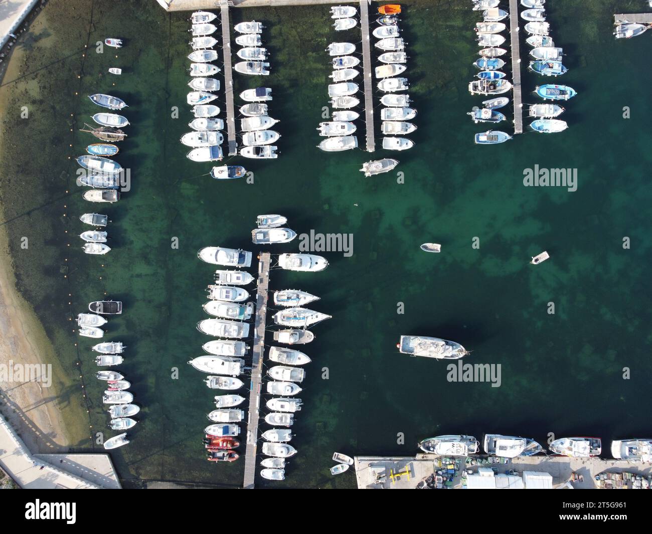 Top down aerial view of fishing boats and yachts inside a marina in the ...