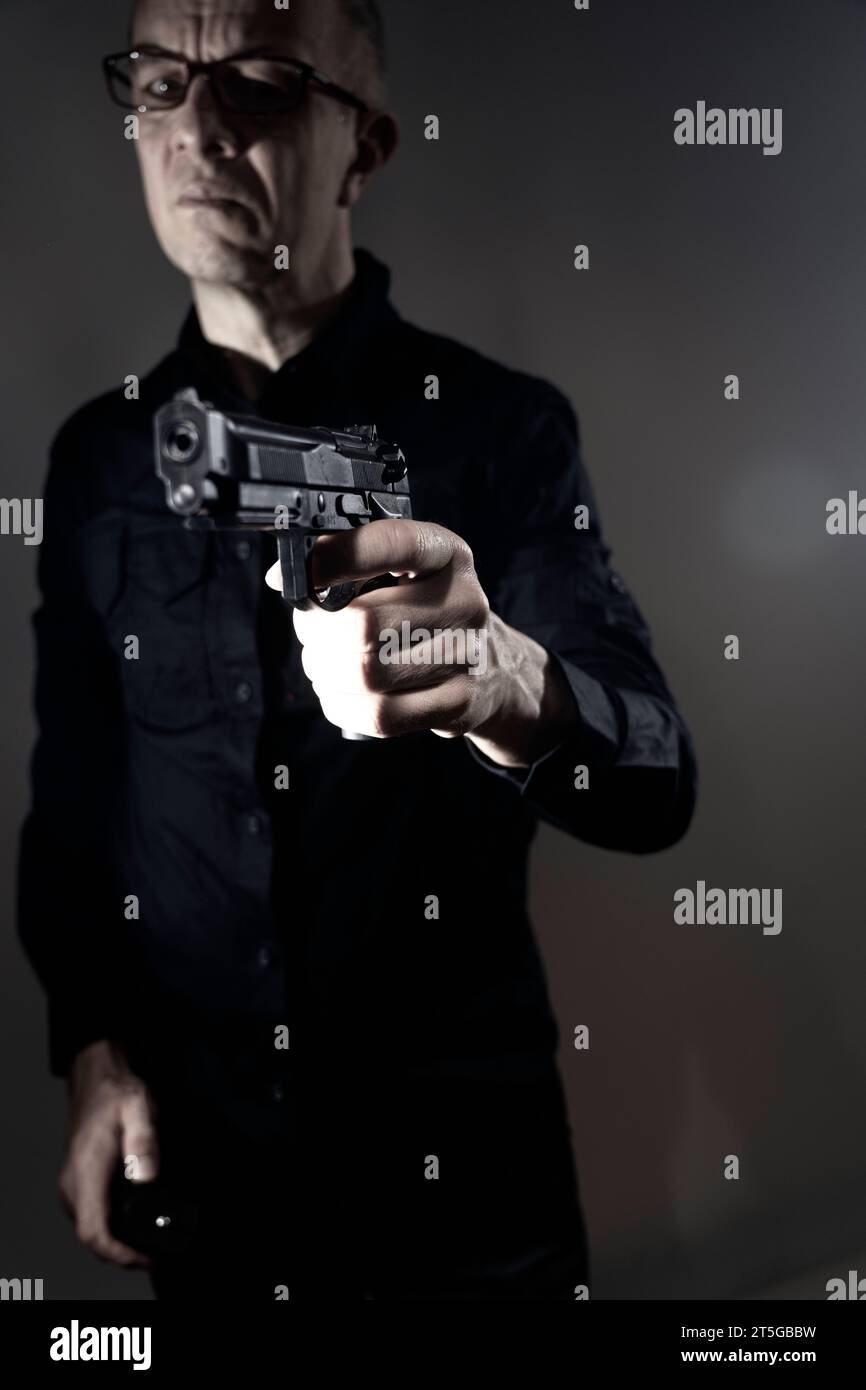 Spy thriller mafia boss assasin portrait photo in suit holding pistol ...