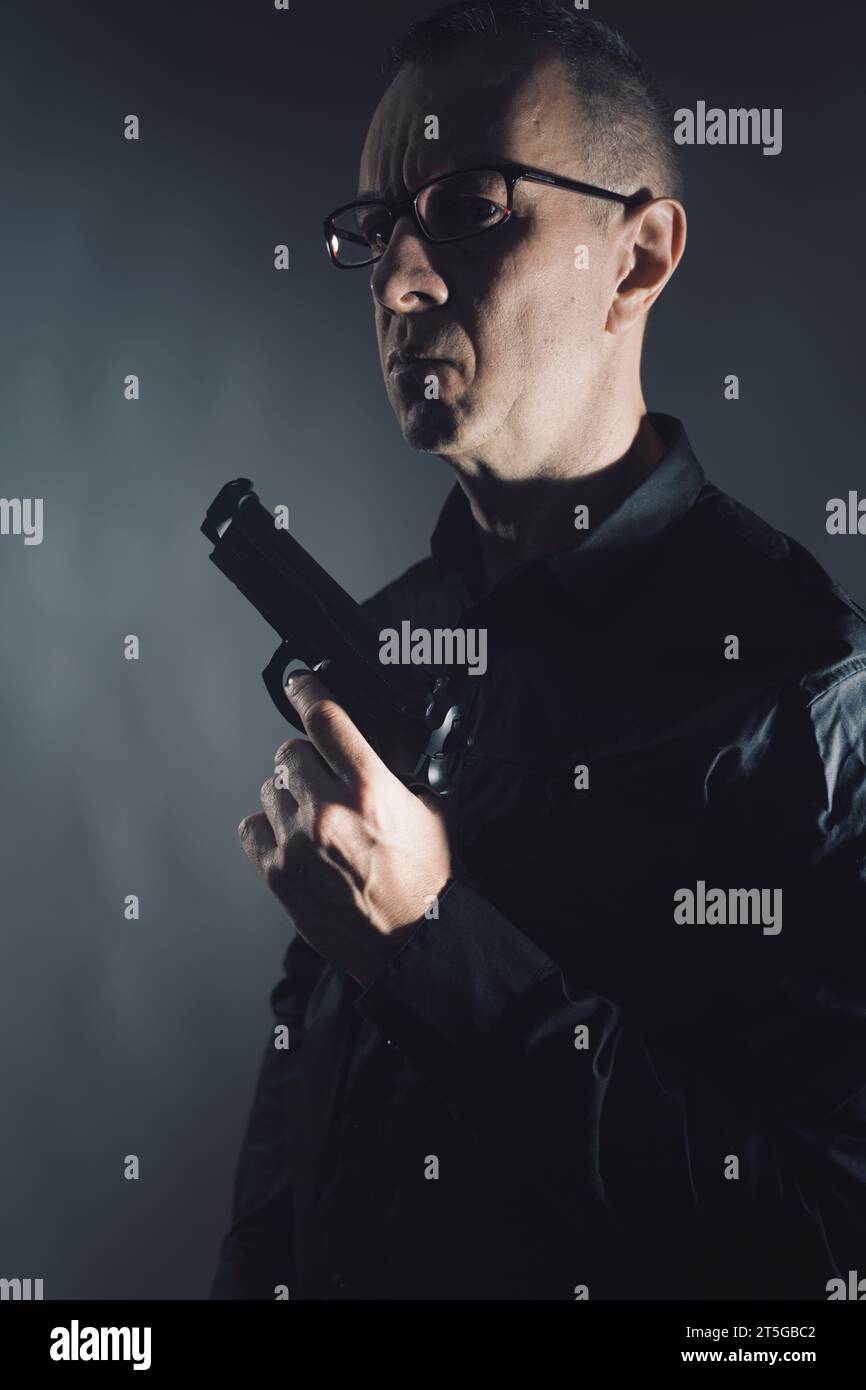 Spy thriller mafia boss assasin portrait photo in suit holding pistol ...