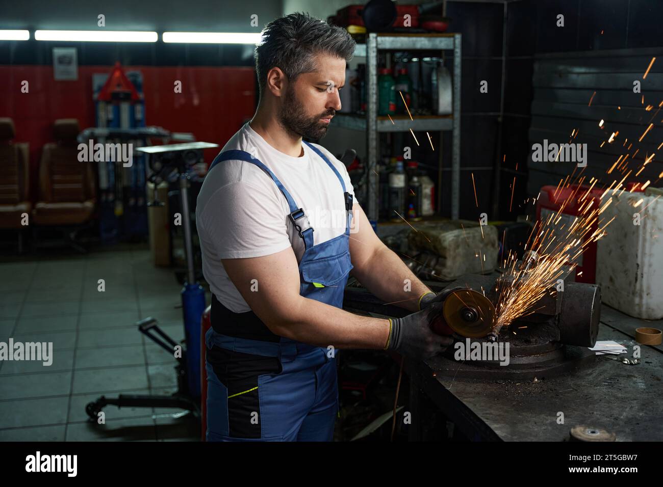 Experienced auto service technician finishing automotive part with ...
