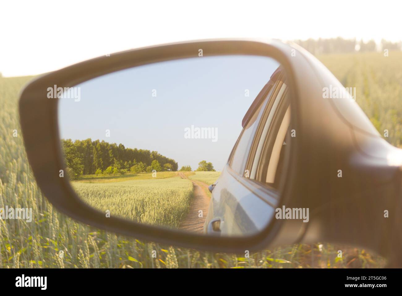 Side mirror of a car. Reflecting sun and fields Stock Photo - Alamy