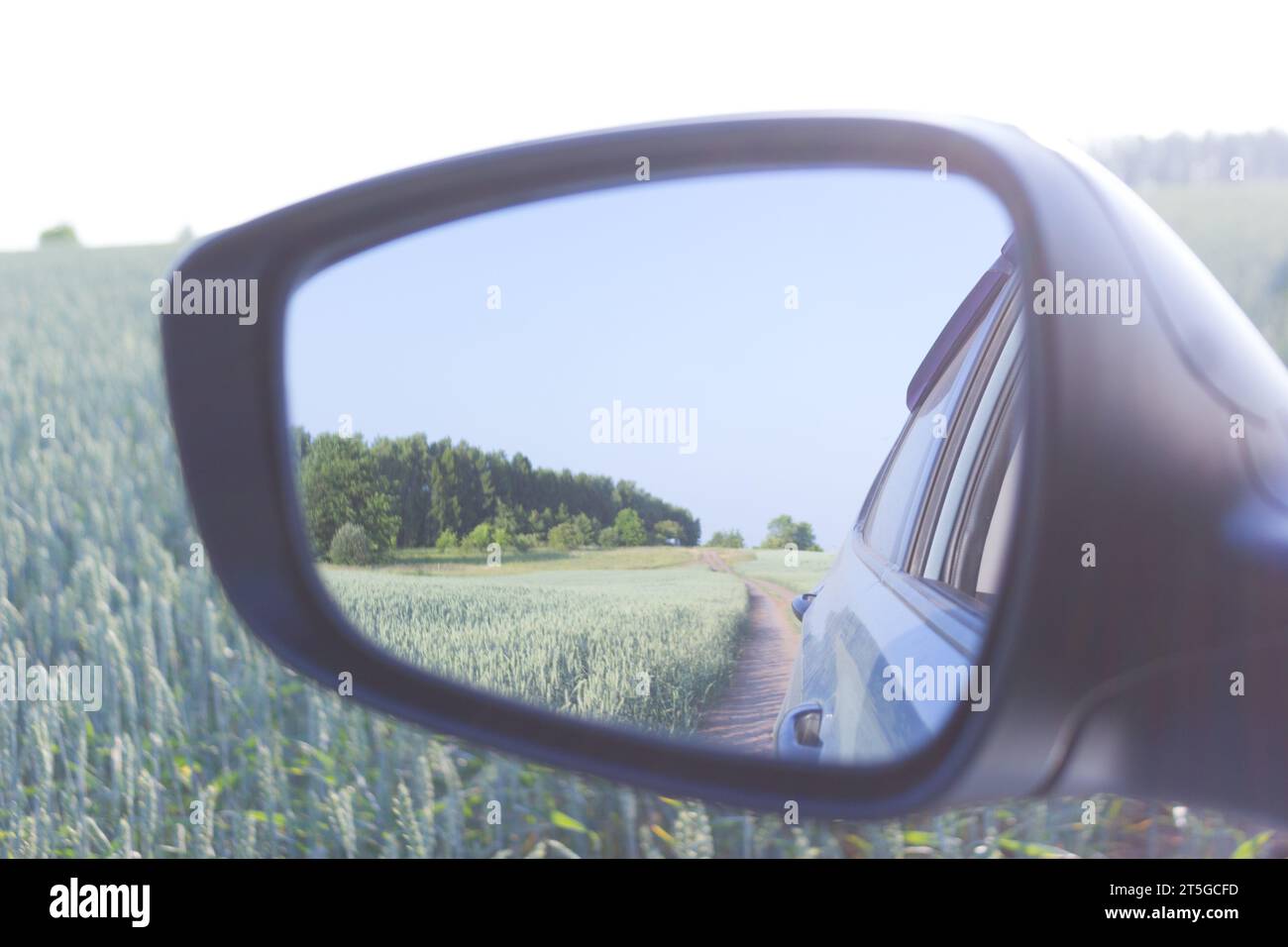 Side mirror of a car. Reflecting sun and fields Stock Photo - Alamy