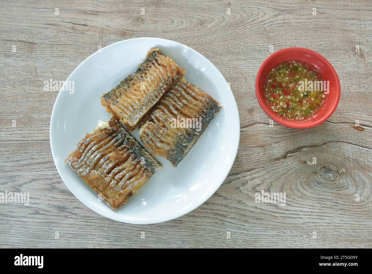 crispy fried chop large head hair tail fish arranging on plate dipping ...
