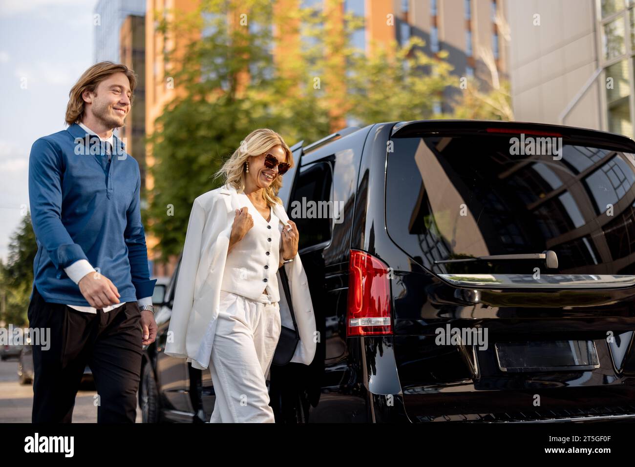 Business people get out of a minivan taxi Stock Photo - Alamy