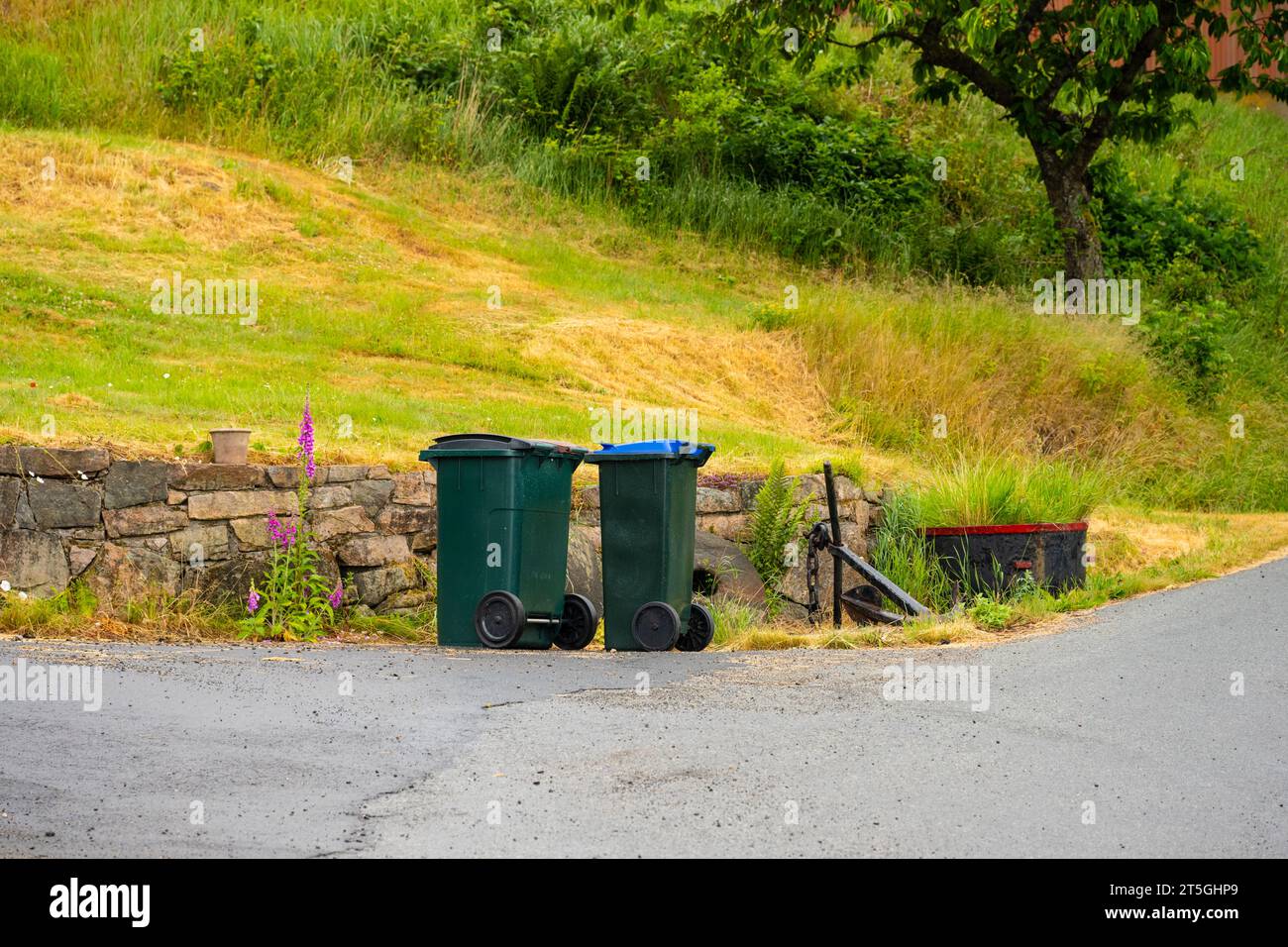 Two trash cans by the side of a road Stock Photo - Alamy