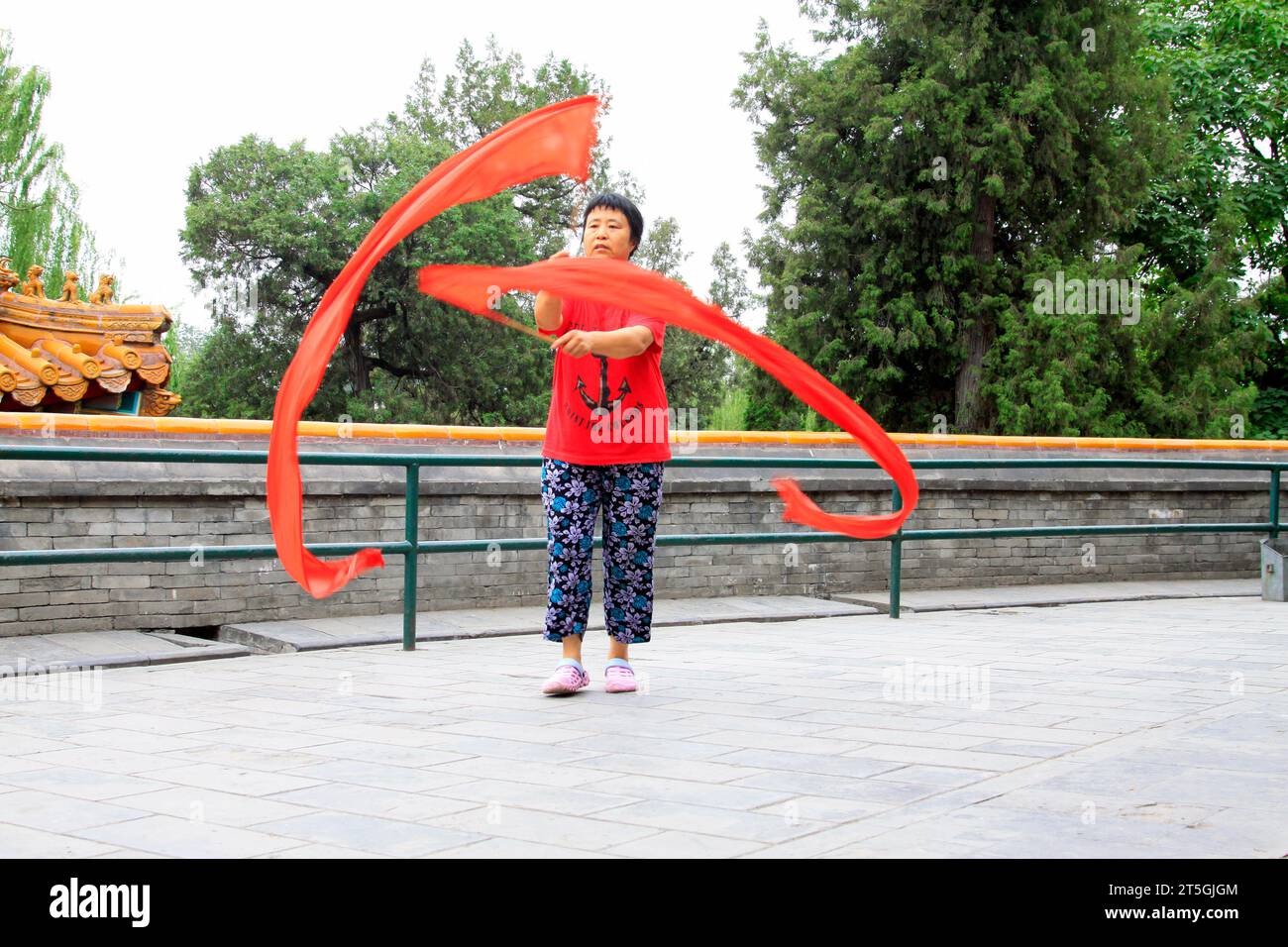 BEIJING - MAY 23: lady was Waving red silk cloth in the Beihai Park，on ...